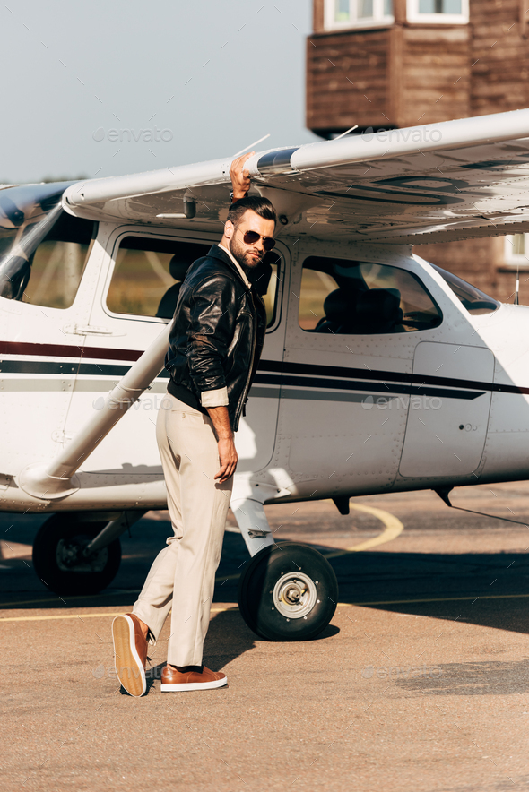 handsome stylish male pilot in leather jacket and sunglasses standing ...