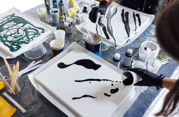 Master class on an Acrylic Fluid Pouring. Young women paint with liquid ...