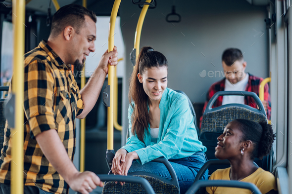Multiracial friends talking while riding a bus in the city Stock Photo ...