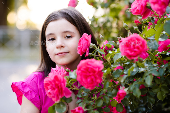 Cute smiling kid girl with rose flowers in park outdoor Stock Photo by ...
