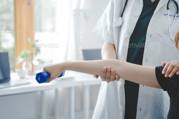 Physical therapist giving dumbbell exercises about the arms and ...