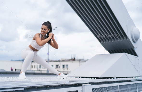 Young happy woman makes deep side lunges to pump muscles of the legs ...