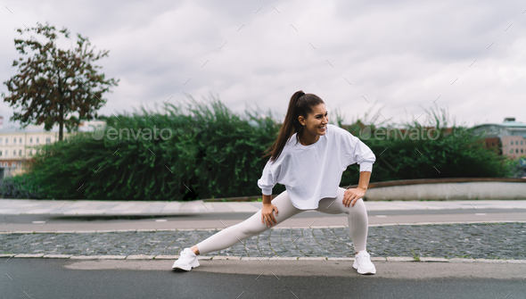 Young happy woman makes deep side lunges to pump muscles of the legs ...
