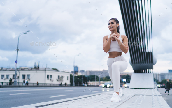 Young woman makes deep forward lunges to pump muscles of the legs and ...
