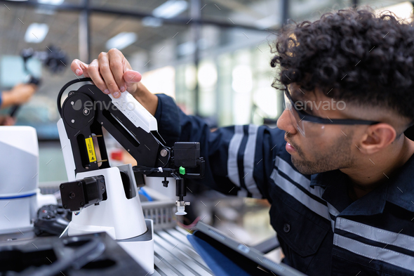 Engineer sitting in robot fab. room use tablet pc quality check robot ...