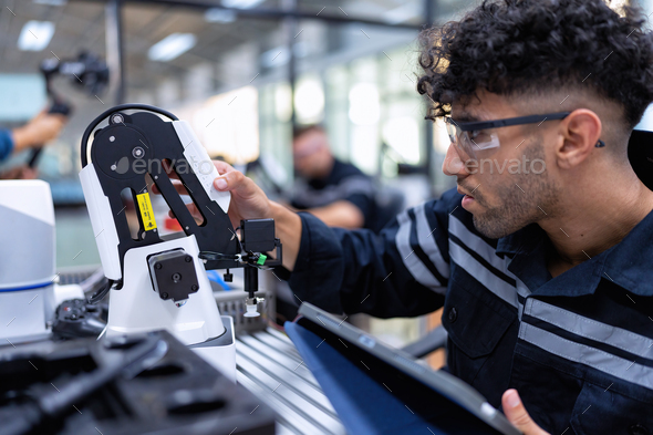 Engineer sitting in robot fab. room use tablet pc quality check robot ...