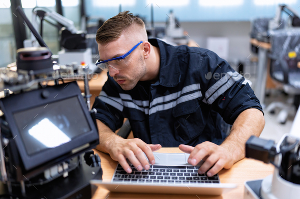 Engineer sitting in robot fab. room use laptop quality check and detail ...