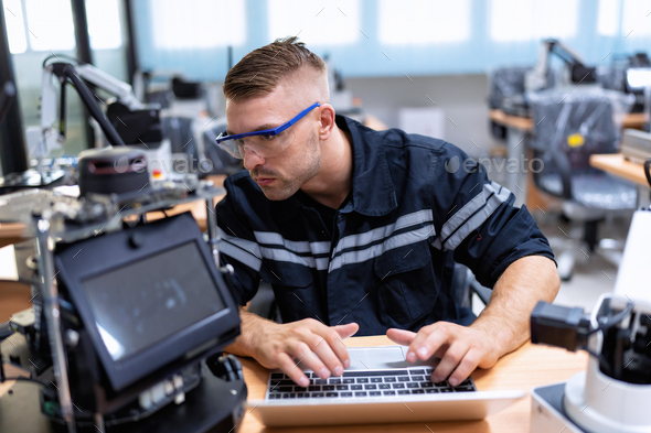 Engineer sitting in robot fab. room use laptop quality check and detail ...