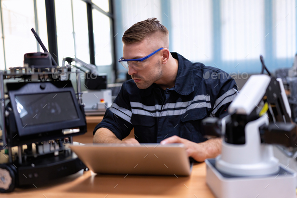 Engineer sitting in robot fab. room use laptop quality check and detail ...