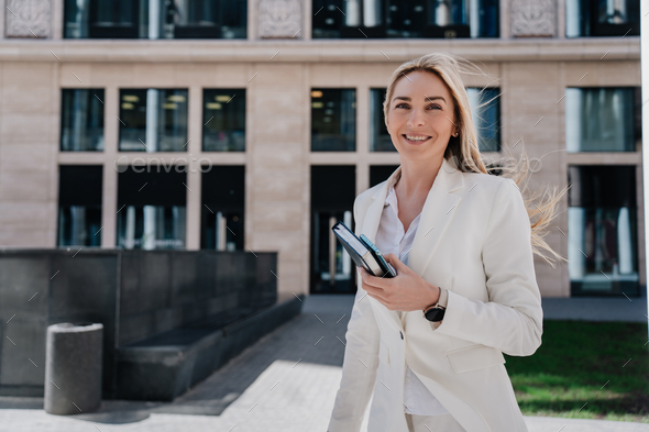 Pretty blonde lawyer woman going to work holding diary and phone ...