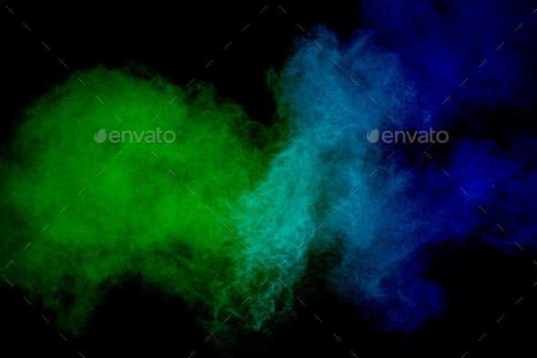 Green and blue powder explosion on black background.Freeze motion of ...