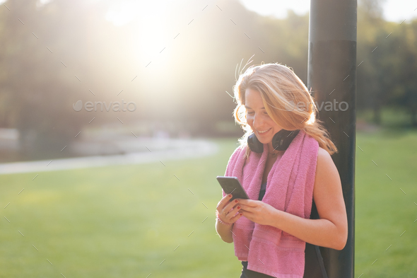 healthy and sporty young woman on mobile smart phone - smiling athlete ...