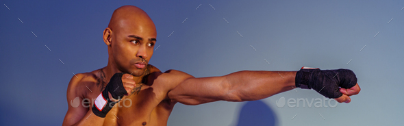 Professional kickboxer is training and practicing punch on studio ...