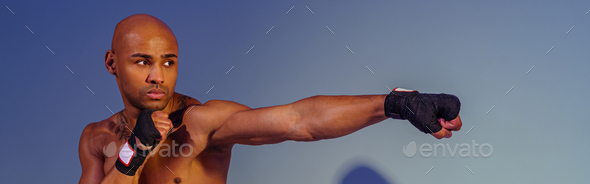 Professional kickboxer is training and practicing punch on studio ...