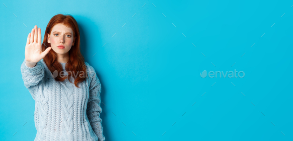 Serious and confident redhead girl telling to stop, saying no, showing ...