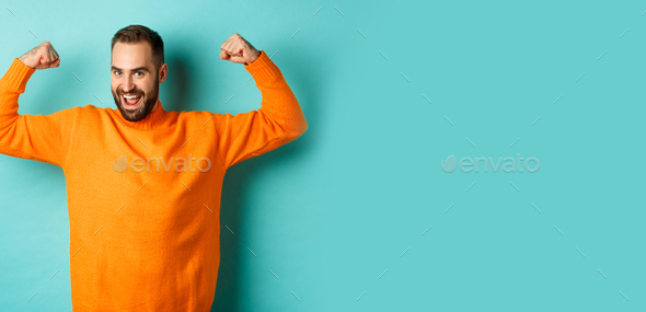 Young and strong man looking confident, flex biceps and show-off muscle ...