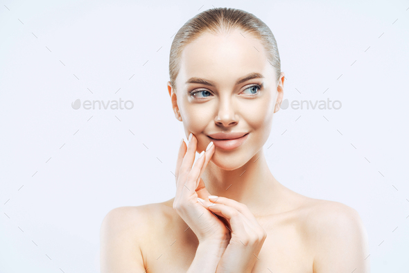 Feminine lady looks aside, touches face gently, gazes sensual and ...