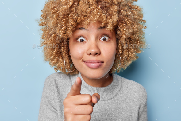 Photo Of Surprised Curly Haired Woman Stares With Wonder Points Index