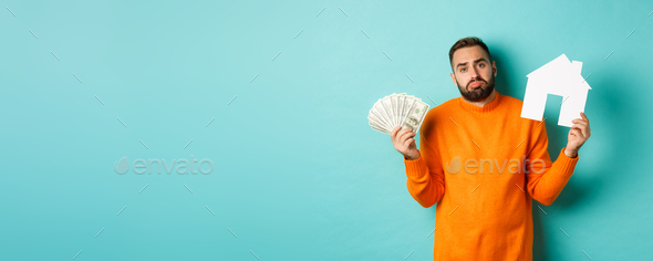 Real estate concept and mortgage concept. Sad and confused man showing ...