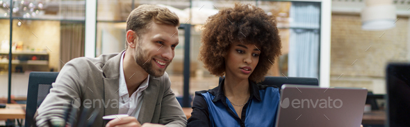 Two businesspartners working together in modern coworking and looking ...