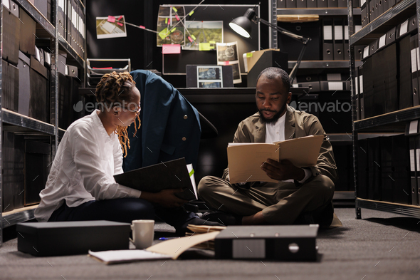 Detective partners sitting on floor surrounded by case files Stock ...
