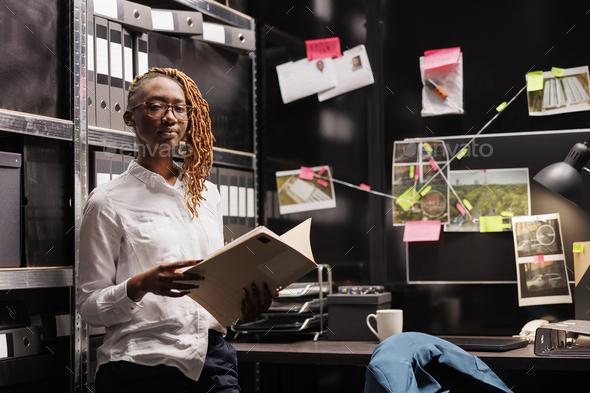 Confident police detective holding crime case file portrait Stock Photo ...