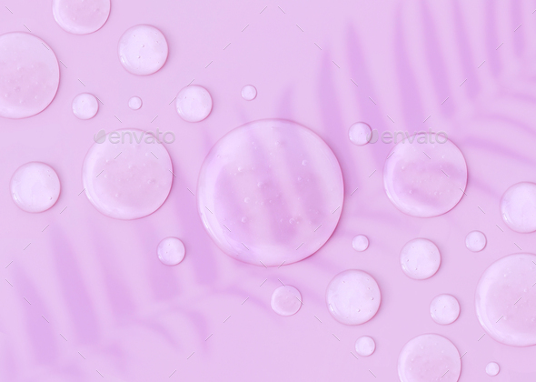 round drops of transparent gel serum on pink background Stock Photo by ...
