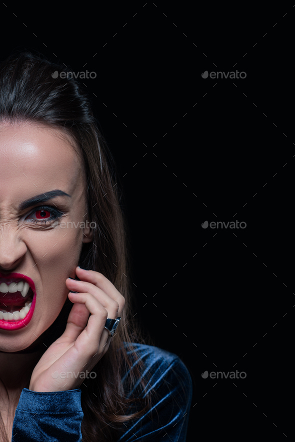 half face portrait of woman showing vampire fangs isolated on black ...