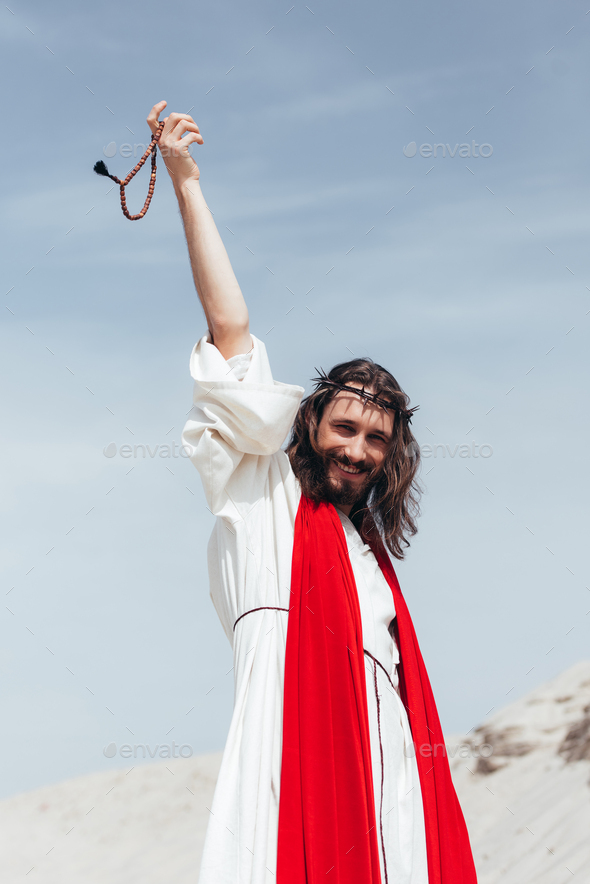 happy Jesus in robe, red sash and crown of thorns holding rosary in ...
