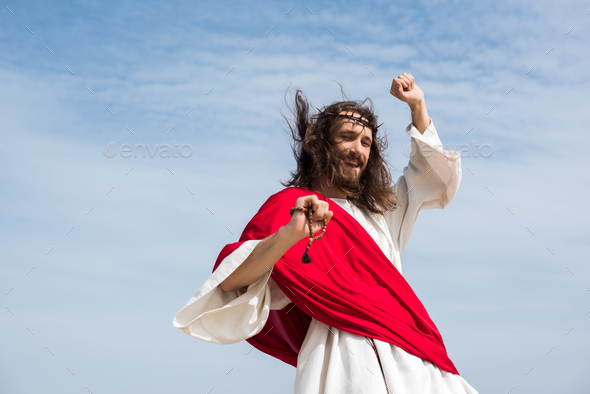 low angle view of Jesus in robe, red sash and crown of thorns having ...