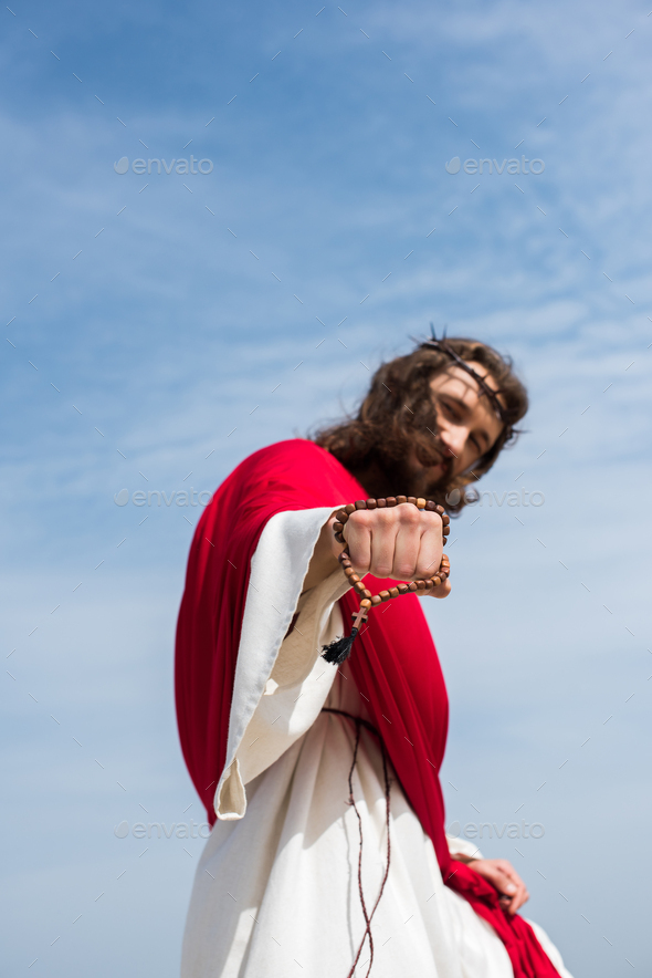low angle view of Jesus in robe, red sash and crown of thorns showing ...