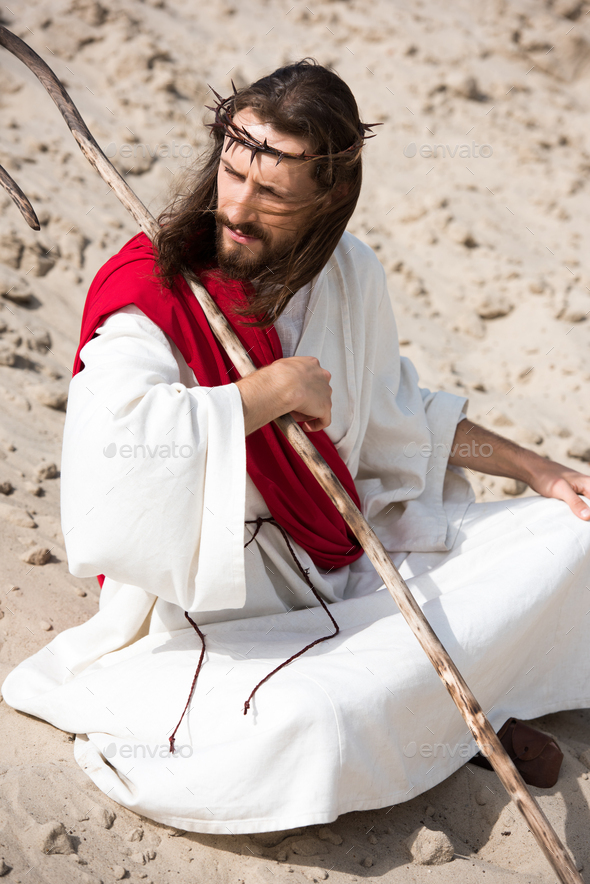 Jesus in robe, red sash and crown of thorns sitting in lotus position ...