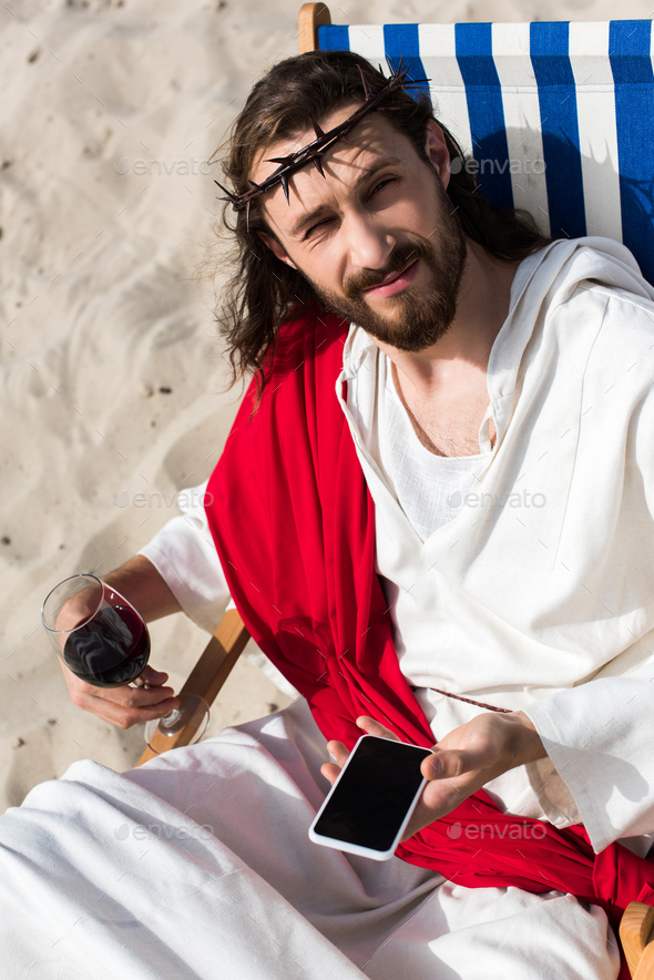 Jesus resting on sun lounger with glass of wine and holding smartphone ...