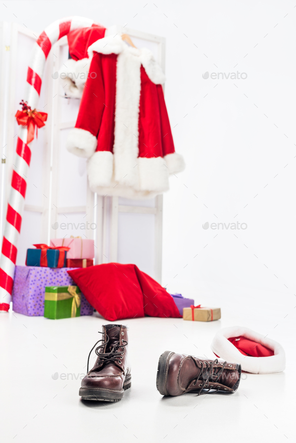 selective focus of boots and christmas stick, pile of gift boxes and ...