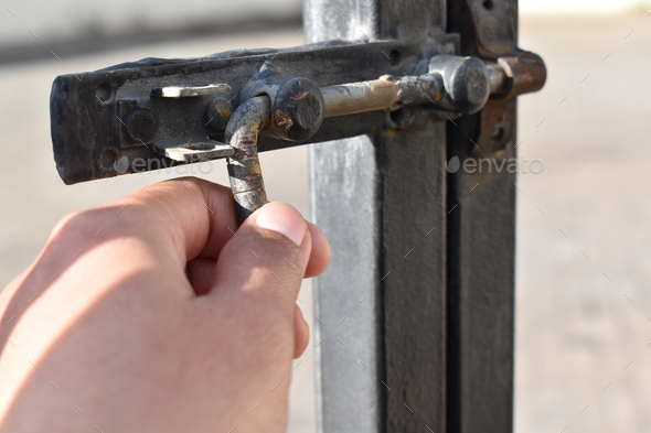Human hand bolting a gate. Steel sliding bolt lock on the gate. Stock ...