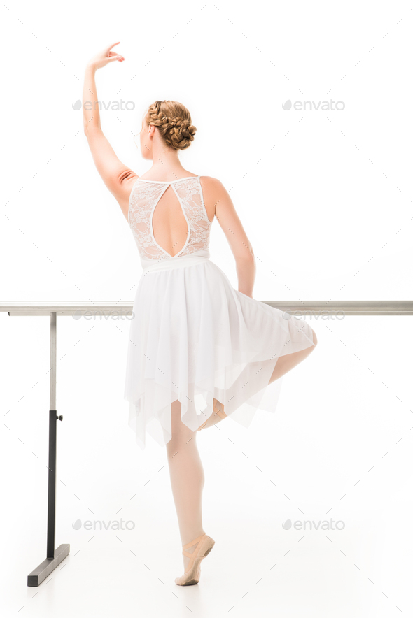 rear view of ballerina in tutu and pointe shoes practicing at ballet ...