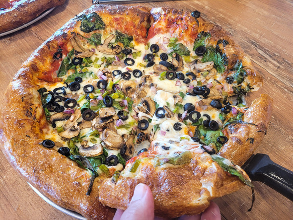 Overhead food flat lay hand picking up pizza slice to eat. Stock Photo ...