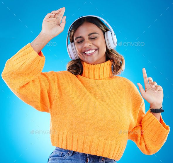 Music headphones, smile and woman dance in studio isolated on a blue ...