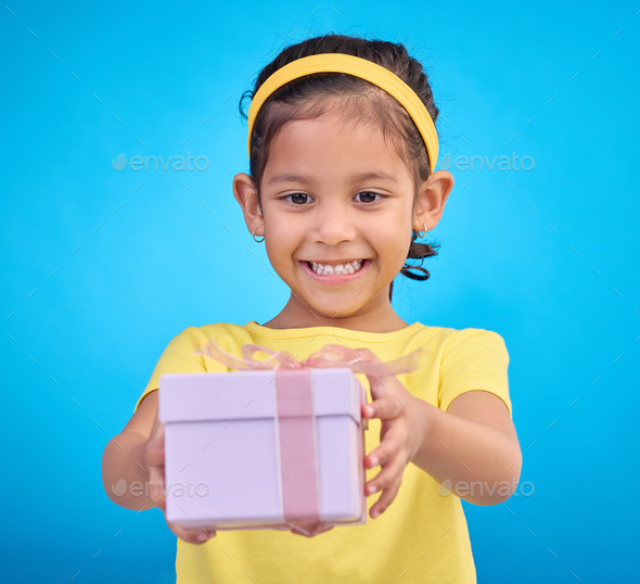 Box, present and girl with smile, excited and cheerful against a blue ...