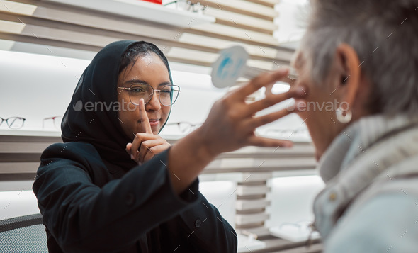 Optometry, vision and eye test with an islamic woman optician working ...