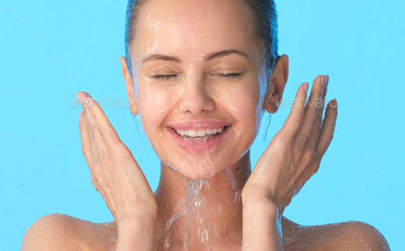 Woman washing her clean face with water. Closeup face of an Young girl ...