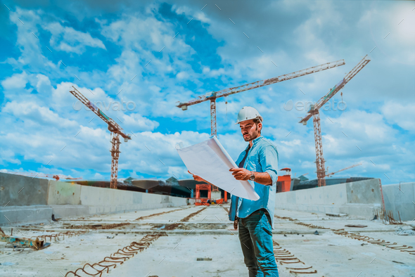 Engineer look at project blueprints for thinking about building project ...
