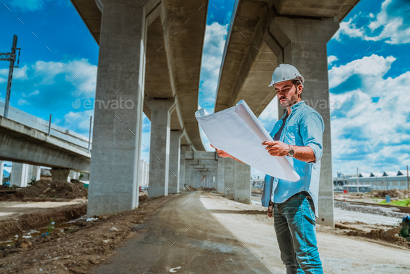 Engineer look at project blueprints for thinking about building project ...
