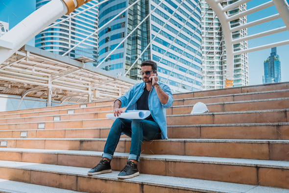 Engineer look at project blueprints for thinking about building project ...