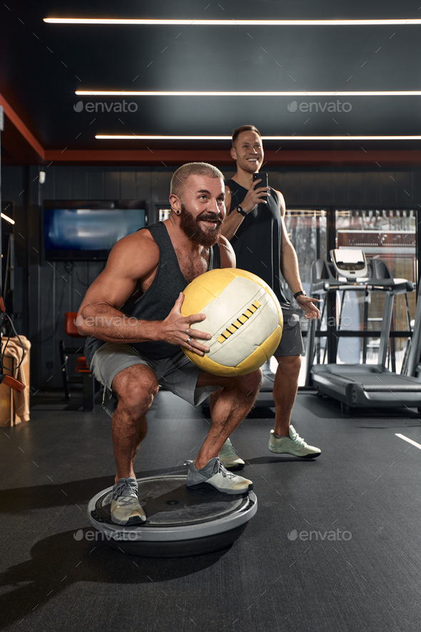 The guys tries to keep his balance on the balancing platform with ...