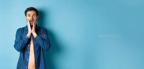 Portrait of guy gasping and dropping jaw with shocked face, staring at ...