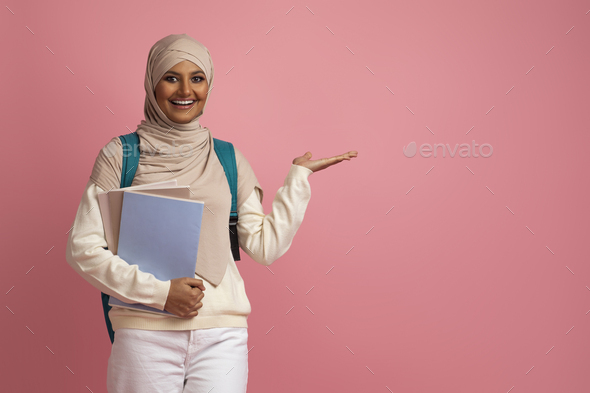 Happy Muslim Female Student In Hijab Pointing At Copy Space With Palm ...