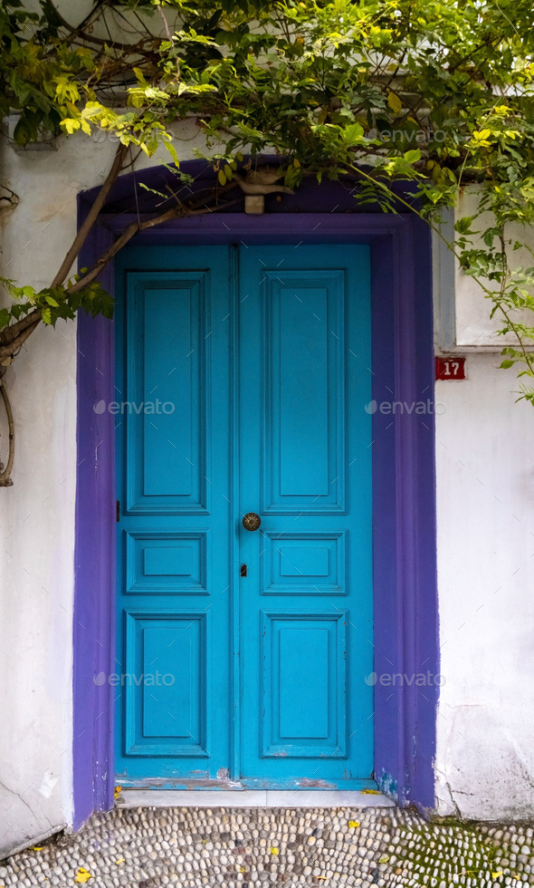 Old blue wooden door with violet frame in white wall. European ...