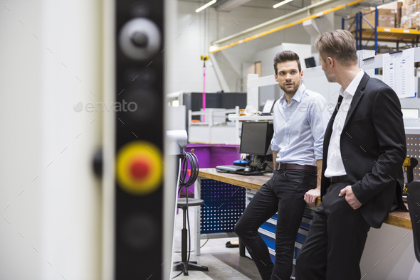 Two men talking in factory shop floor Stock Photo by westend61 | PhotoDune