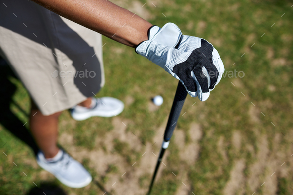 Top view closeup of gloved female hand holding golf club against grass ...
